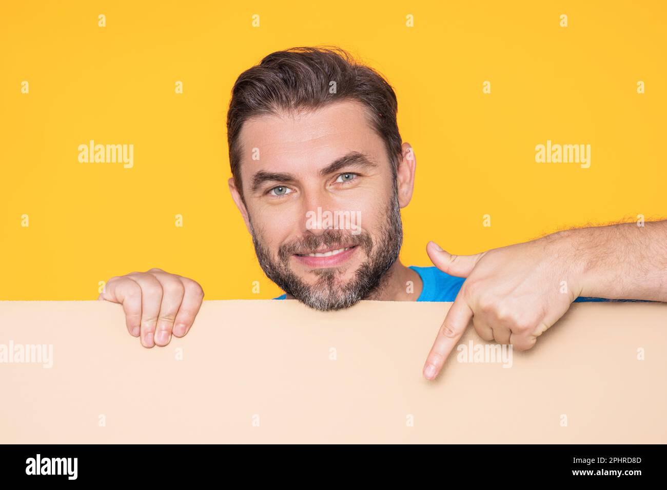 Man showing promo holding pointing finger on blank board on studio ...