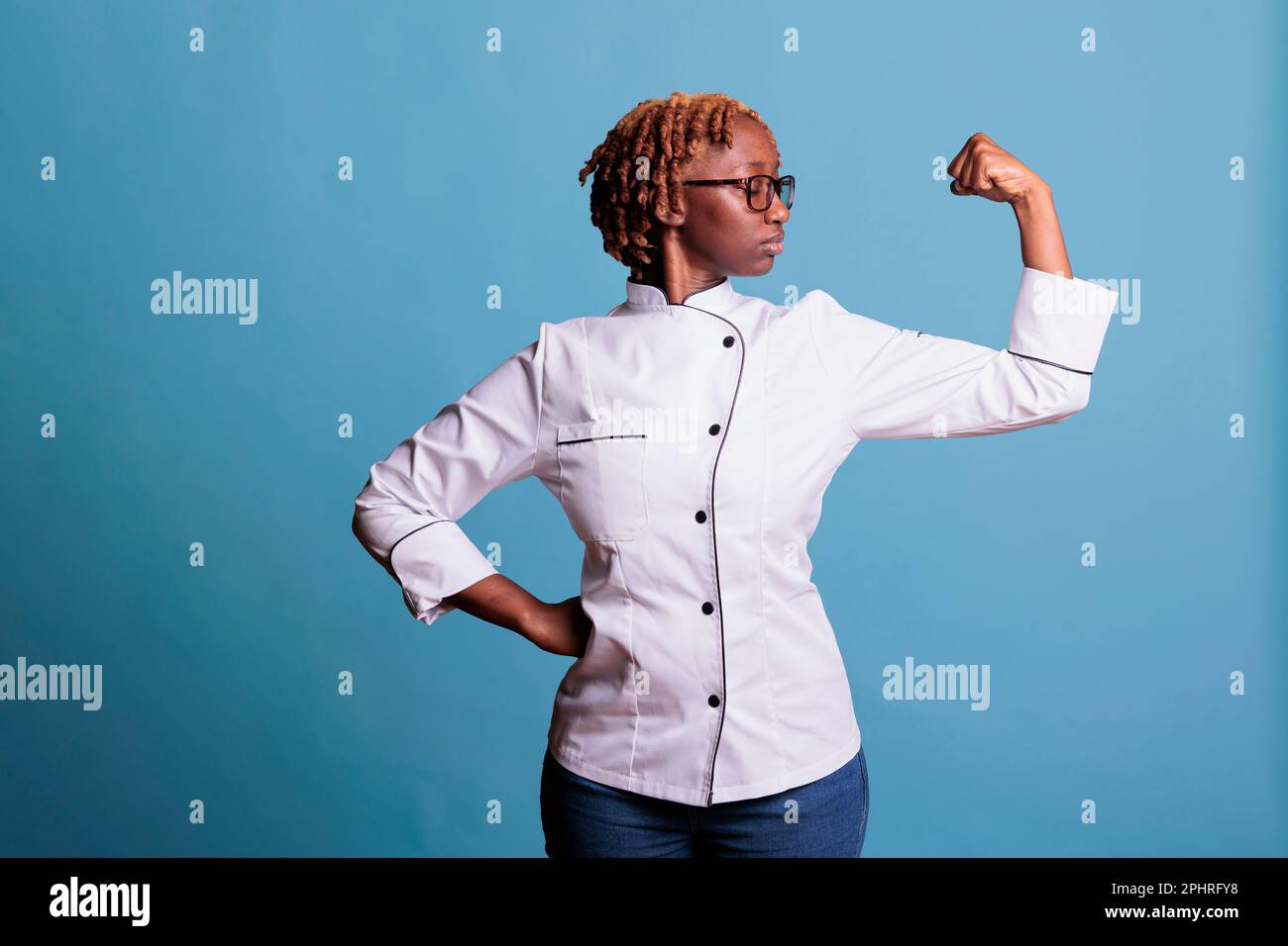Professional cooking woman flexing arm with pose of power and strength ...