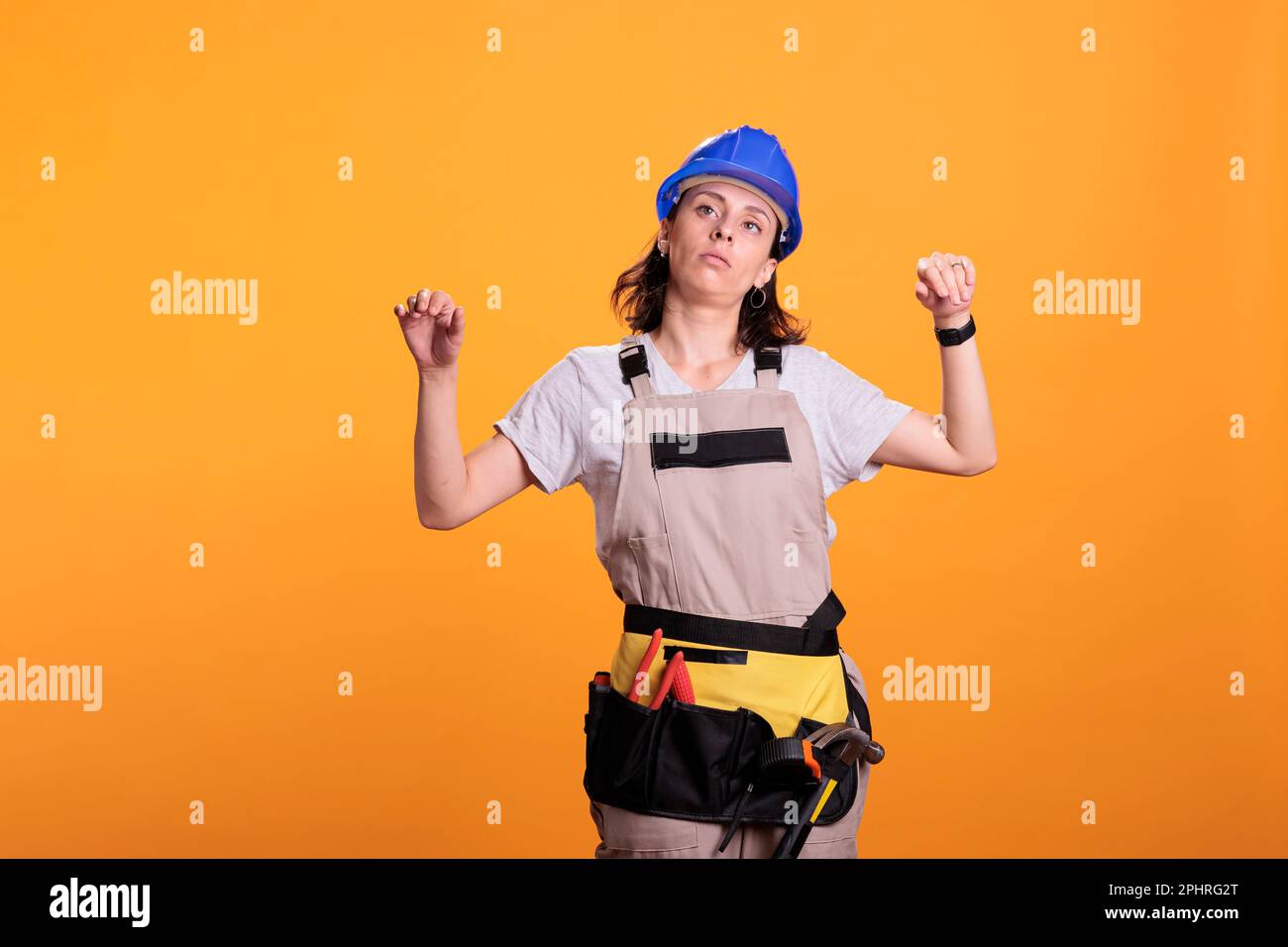 Female construction worker acting dizzy and tired, standing over yellow ...