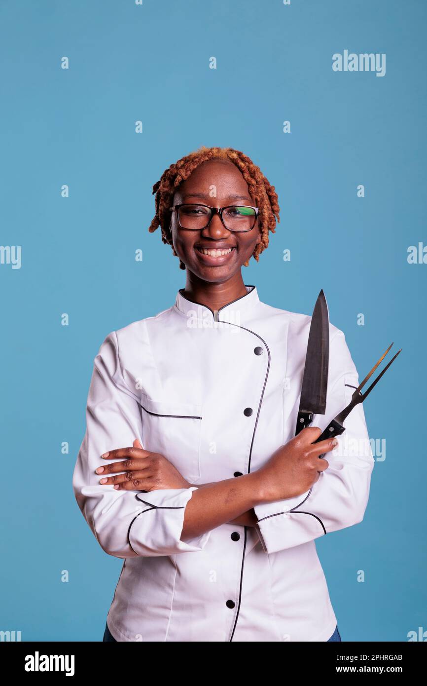 African american female cooker, curly haired posing with professional ...