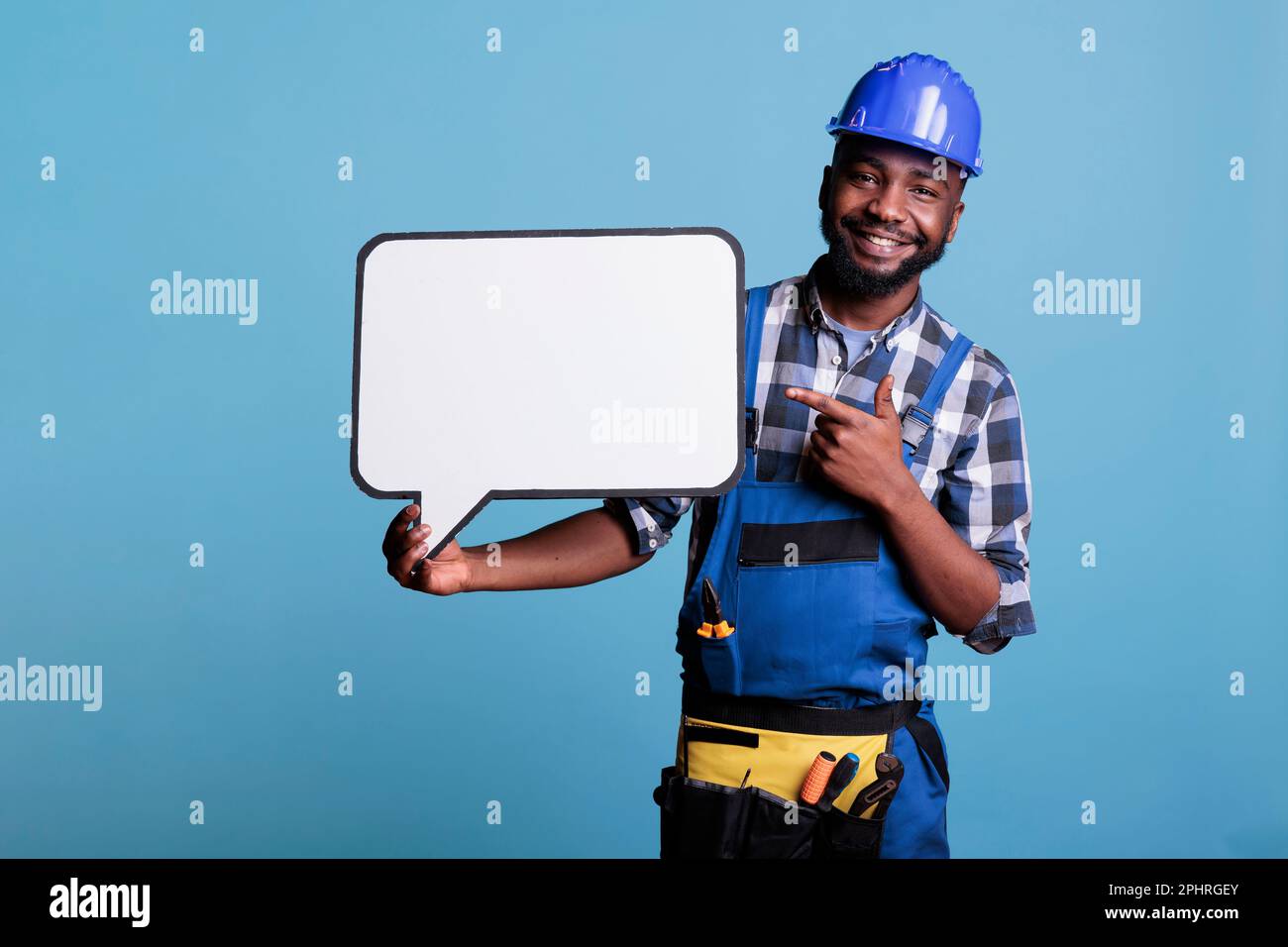 Optimistic african american man pointing to empty white dialogue bubble with copy space, showing ...