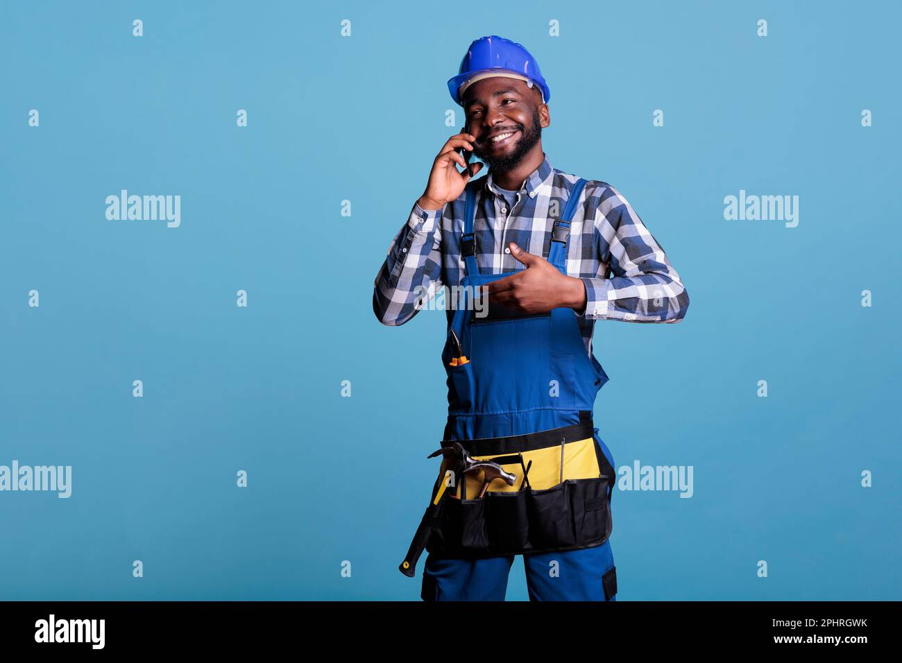 Optimistic african american builder having a nice conversation on cell ...