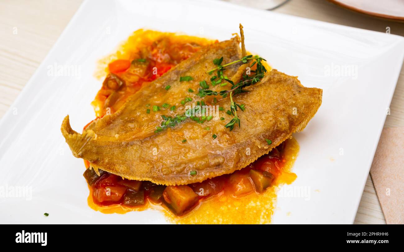Fried sole fish with herbal oil and stewed vegetables Stock Photo - Alamy