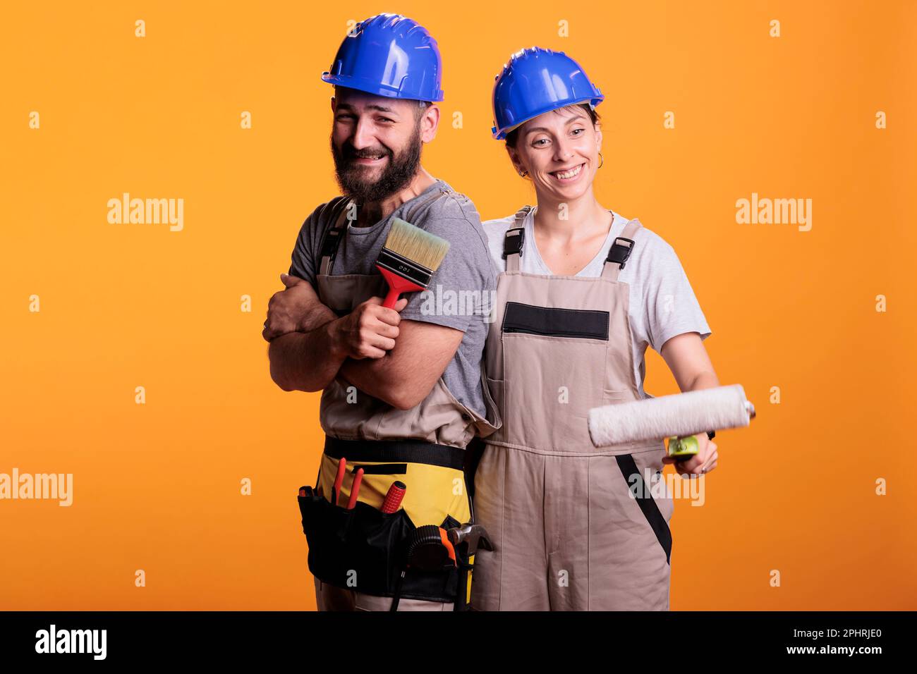 Team of contractors with paintbrush and roller in studio, working on ...