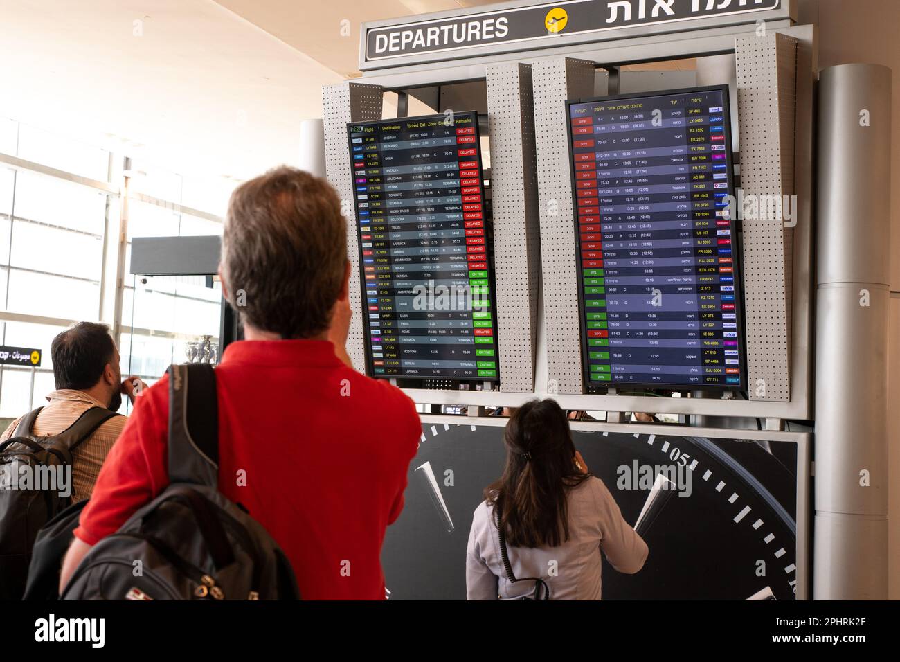 Passengers look at flights announcement board showing delayed flights ...