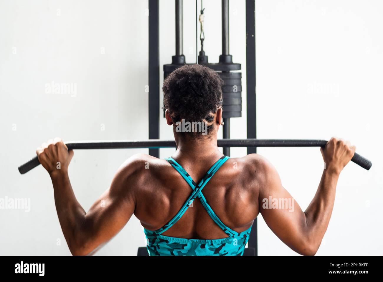 Portrait of muscular woman doing pull-up exercises for back muscles ...