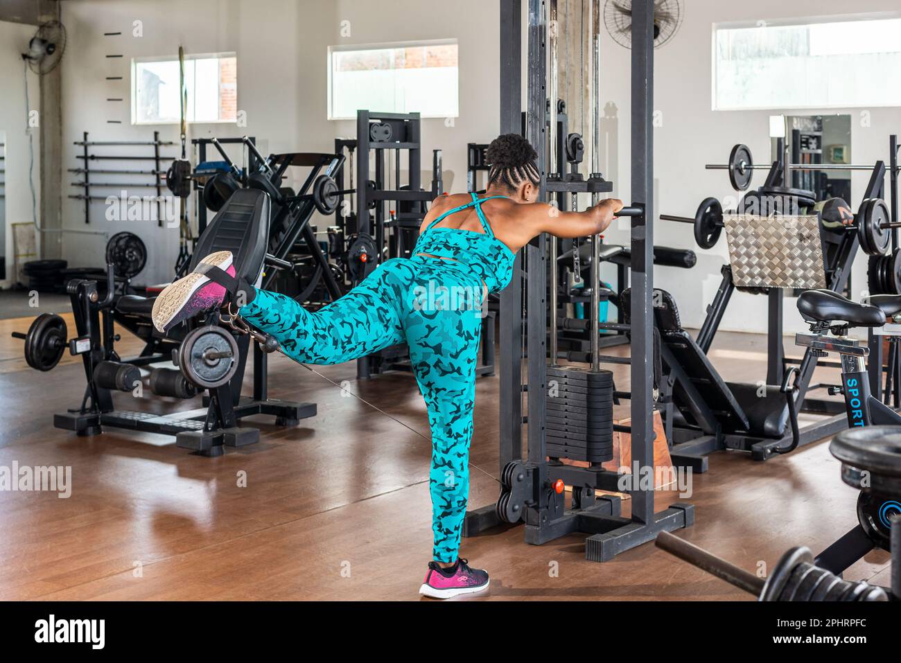 Beautiful woman training leg muscles on the pulley. Bodybuilding ...