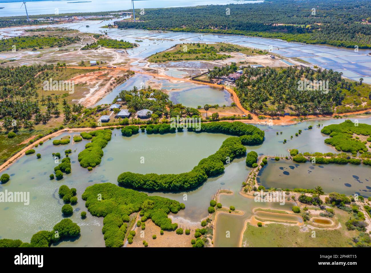 Aerial view of agricultural fields overlooked by wind power turbines at ...
