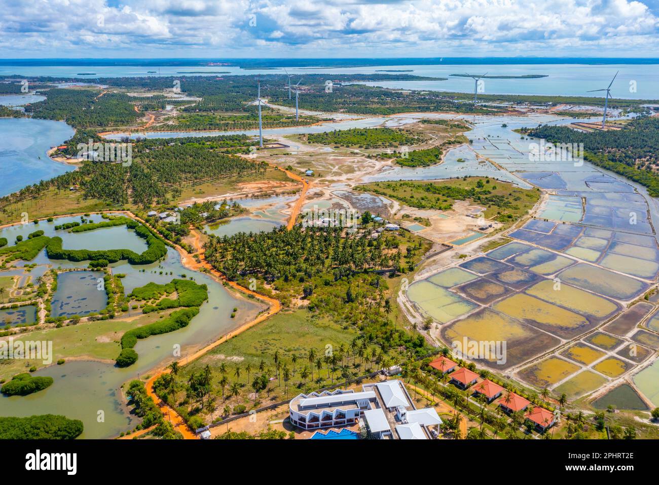Aerial view of agricultural fields overlooked by wind power turbines at ...