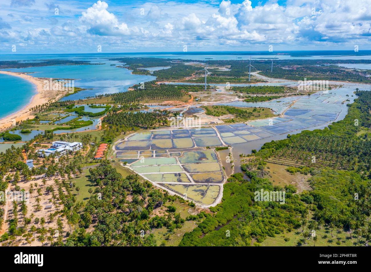 Aerial view of agricultural fields overlooked by wind power turbines at ...