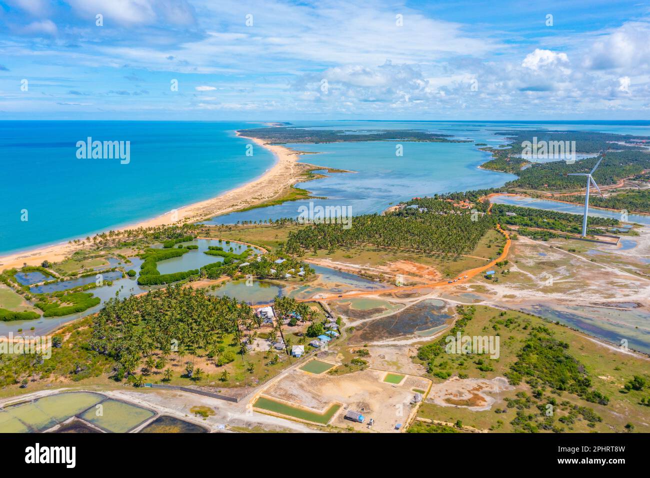 Aerial view of agricultural fields overlooked by wind power turbines at ...