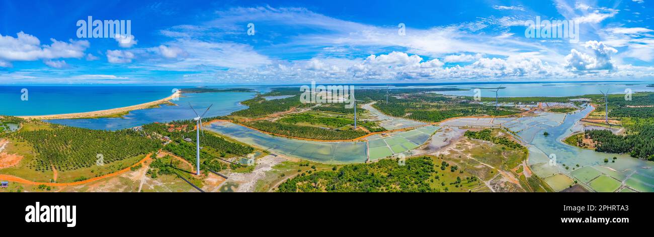 Aerial view of agricultural fields overlooked by wind power turbines at ...