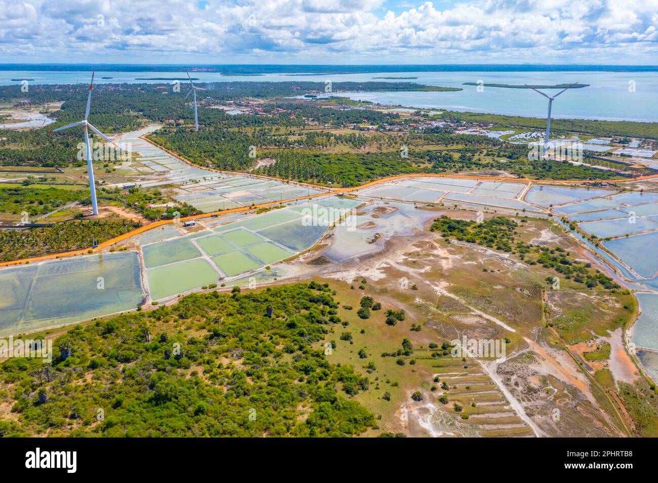 Aerial view of agricultural fields overlooked by wind power turbines at ...