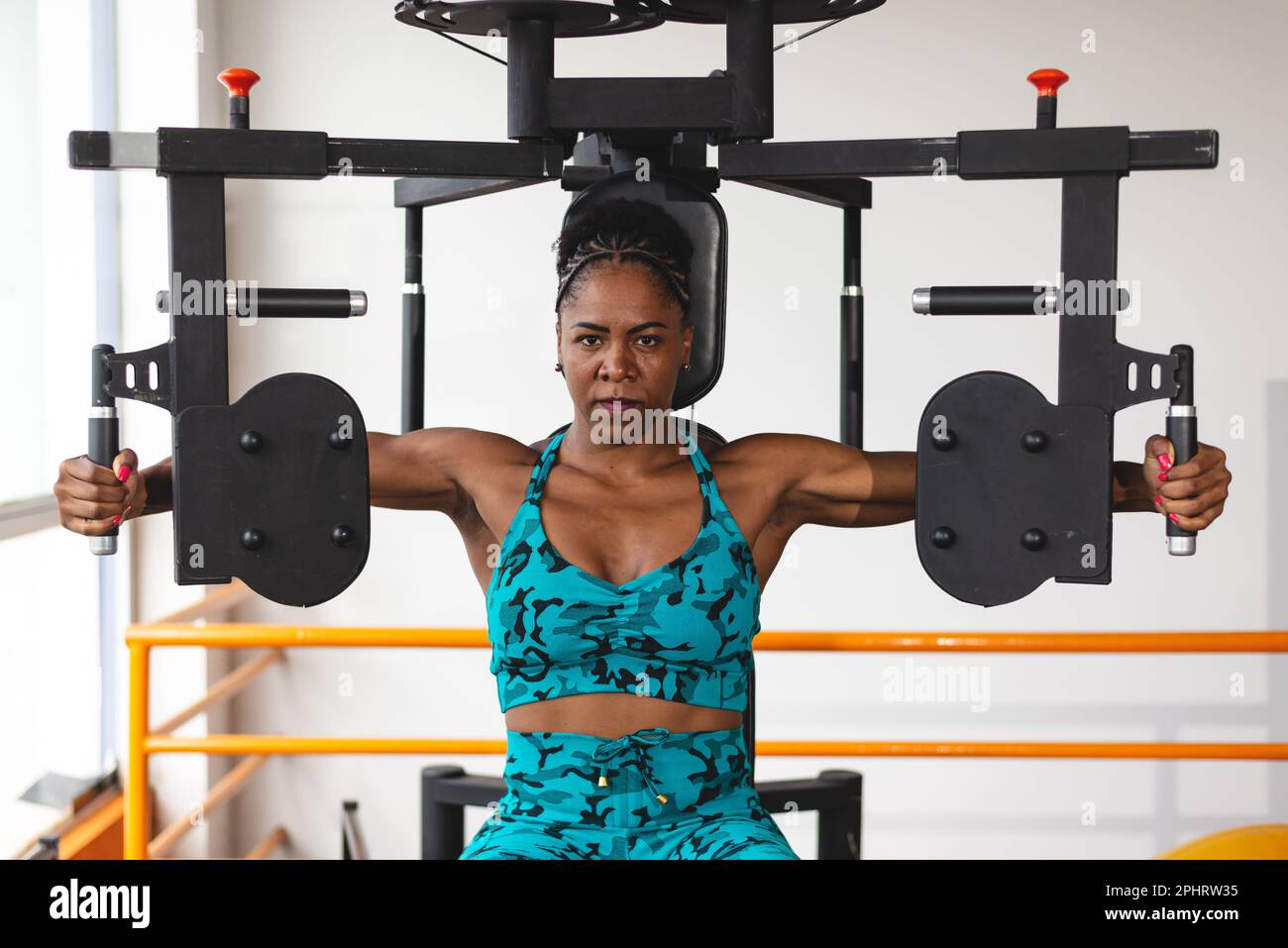 Woman sitting on machine doing arm exercises. Fitness in the studio ...