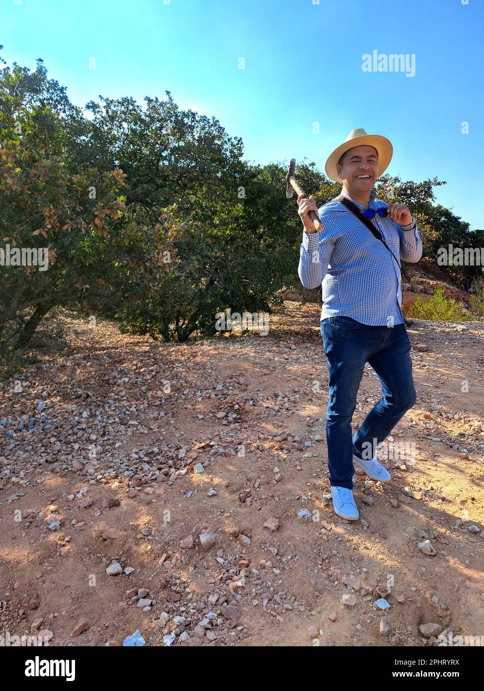 Latin man with hat and miner's pick hammer works as a geologist ...