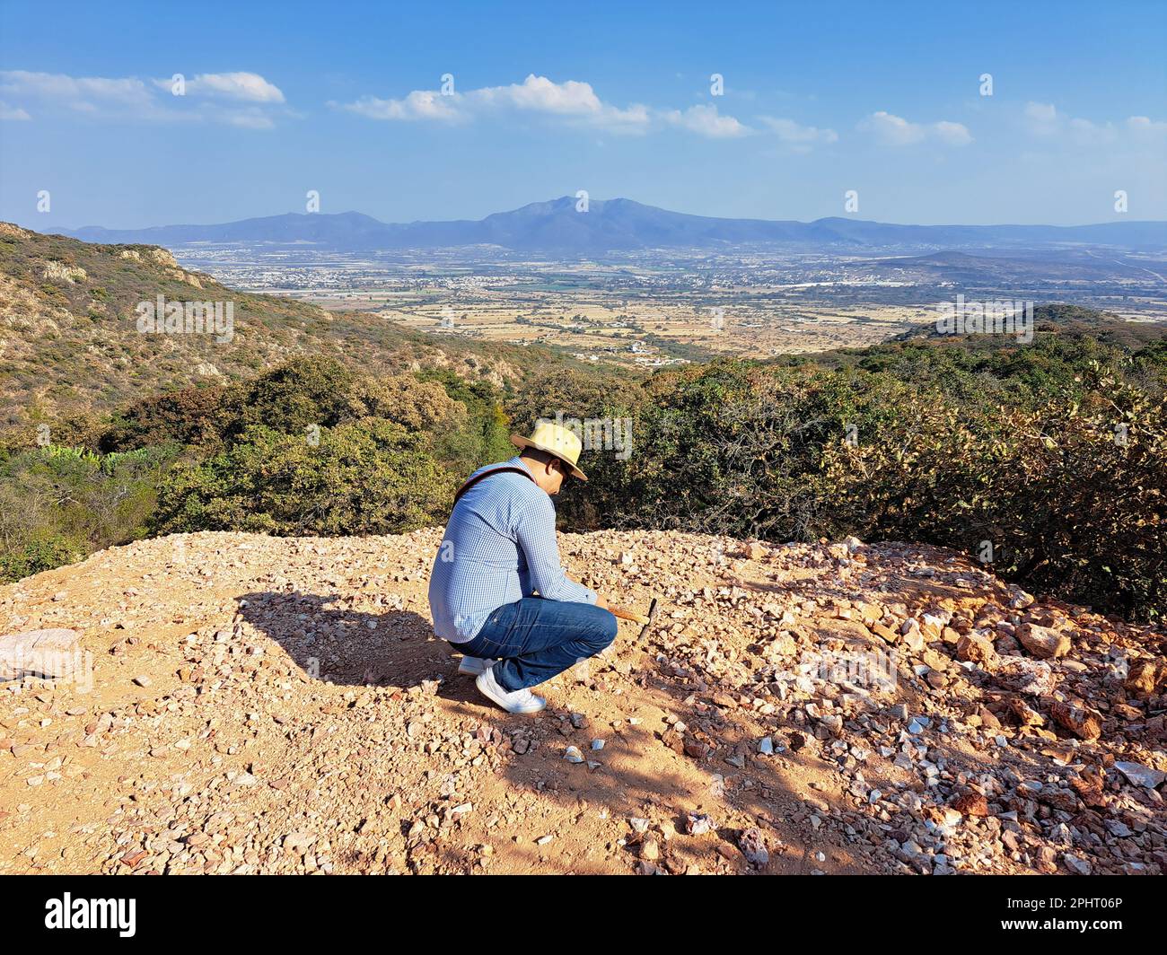 Latin man with hat and miner's pick hammer works as a geologist ...
