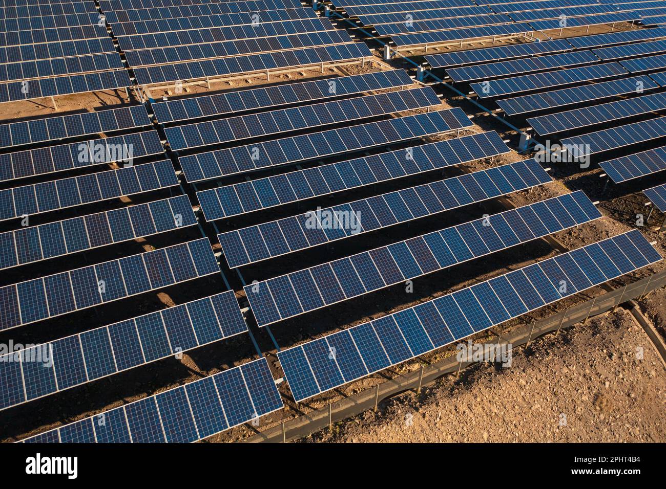 Long rows of photovoltaic panels at solar farm for converting energy of ...