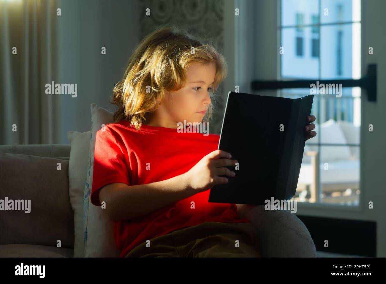 Kid boy reading book at living room. Smart, clever child. Intelligent ...
