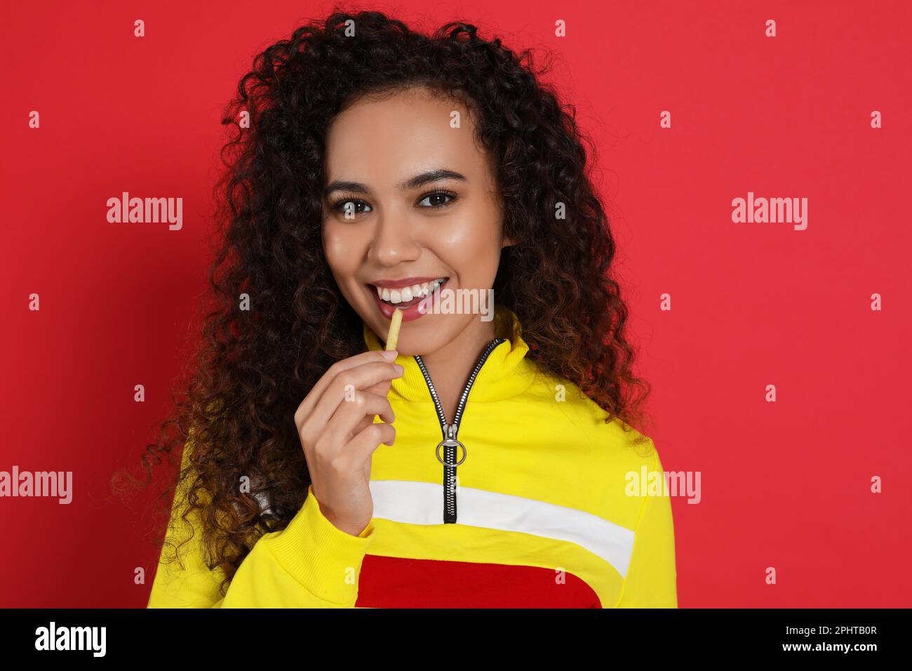 African American woman eating French fries on red background Stock ... African American woman eating French fries on red background Stock ...