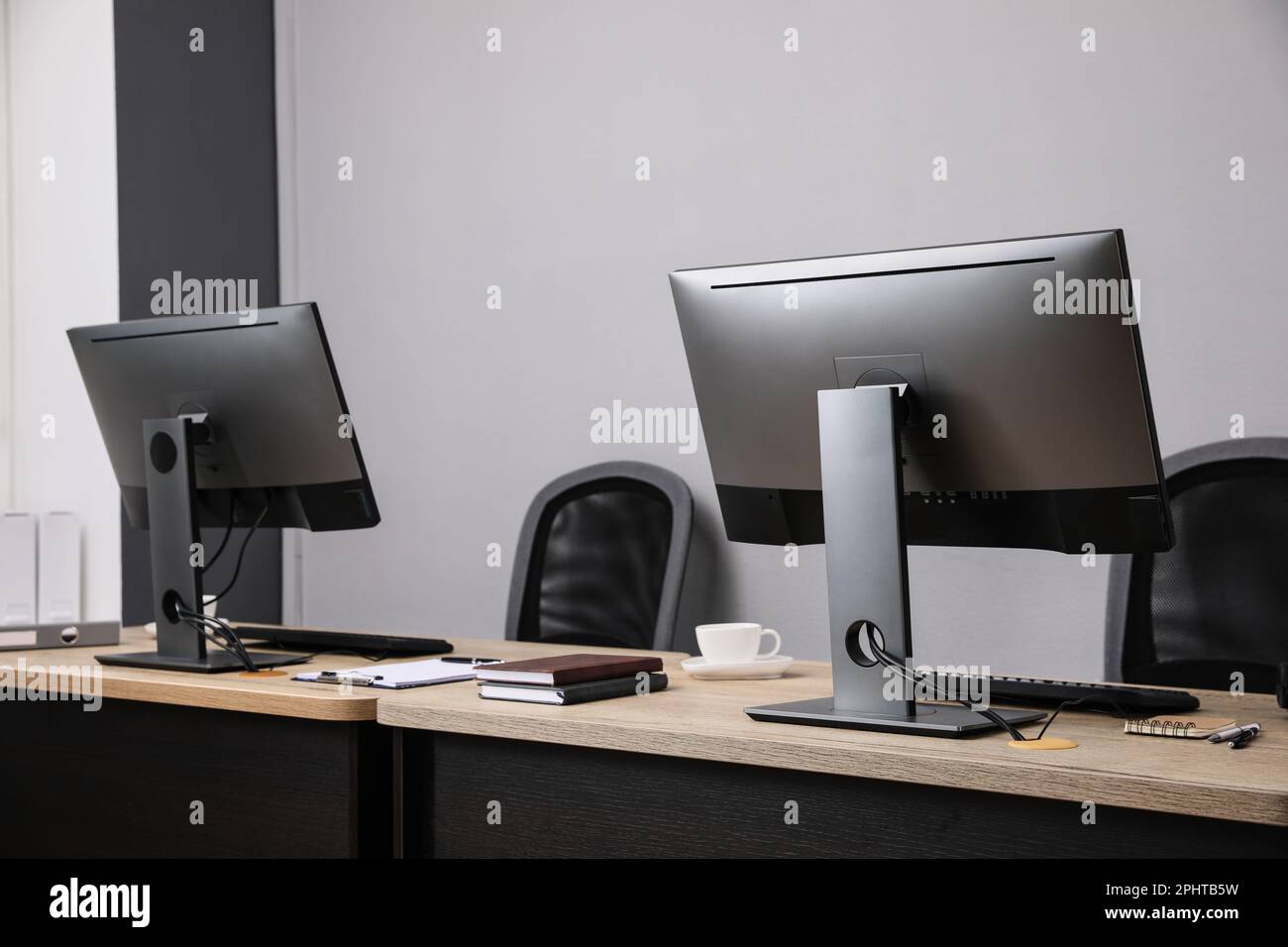 Open office interior. Modern workplaces with computers near light grey ...