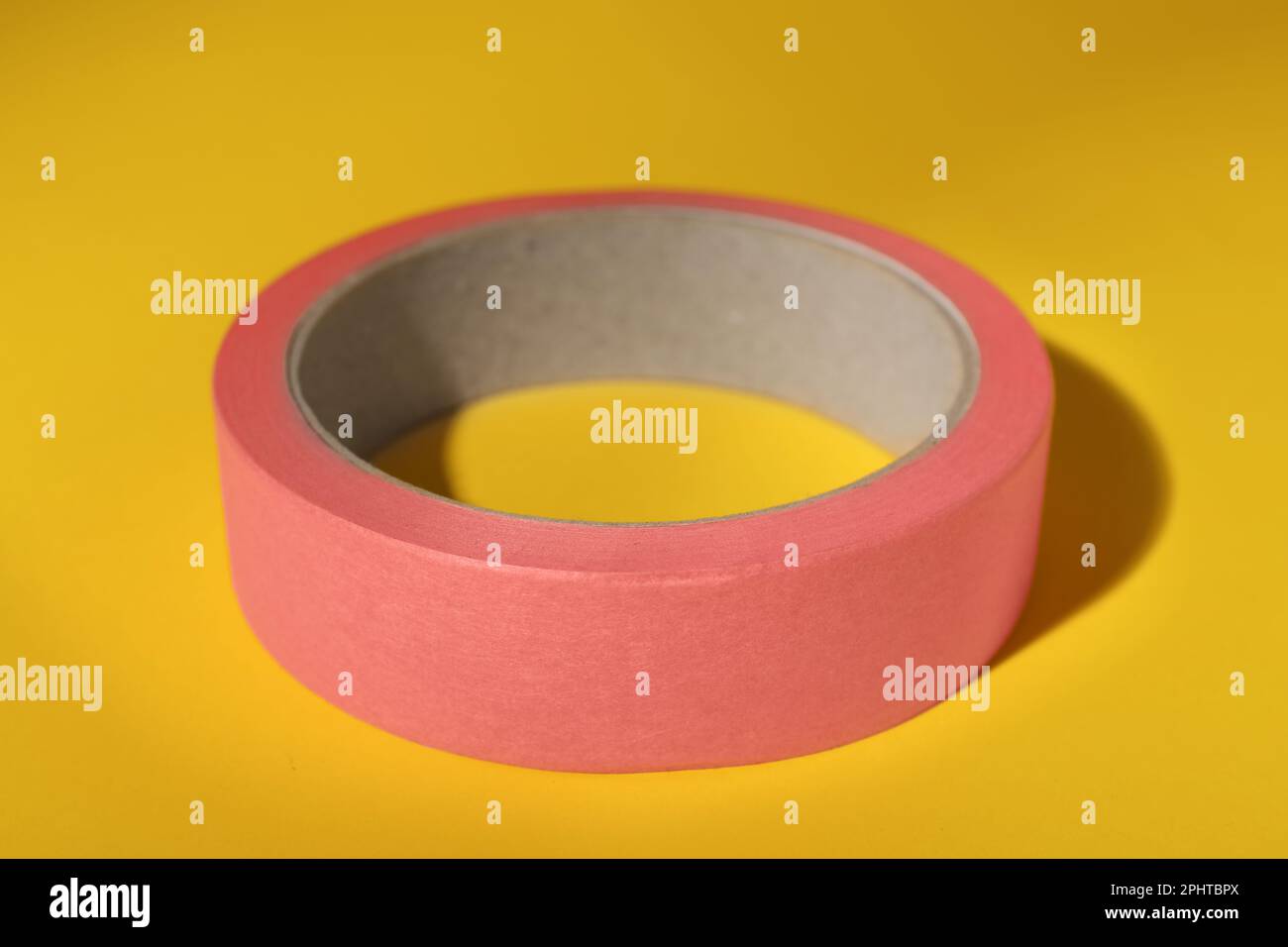 Roll of pink adhesive tape on yellow background Stock Photo - Alamy