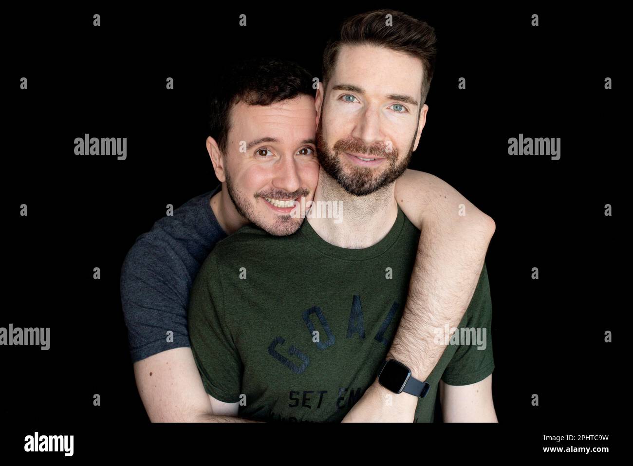Young gay couple smiling and hugging Isolated on Black Background Stock ...