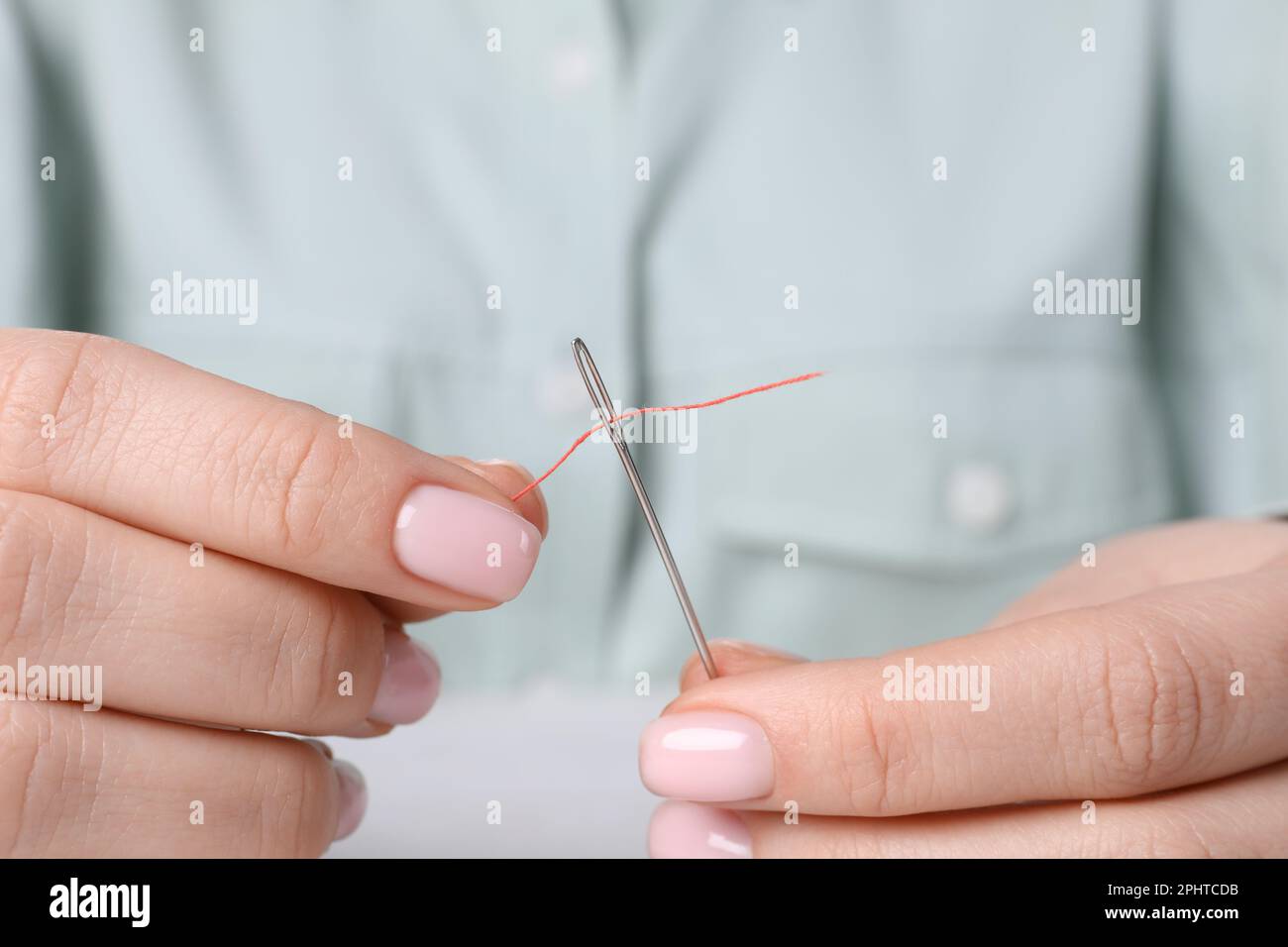 Woman threading needle, closeup view. Sewing equipment Stock Photo - Alamy