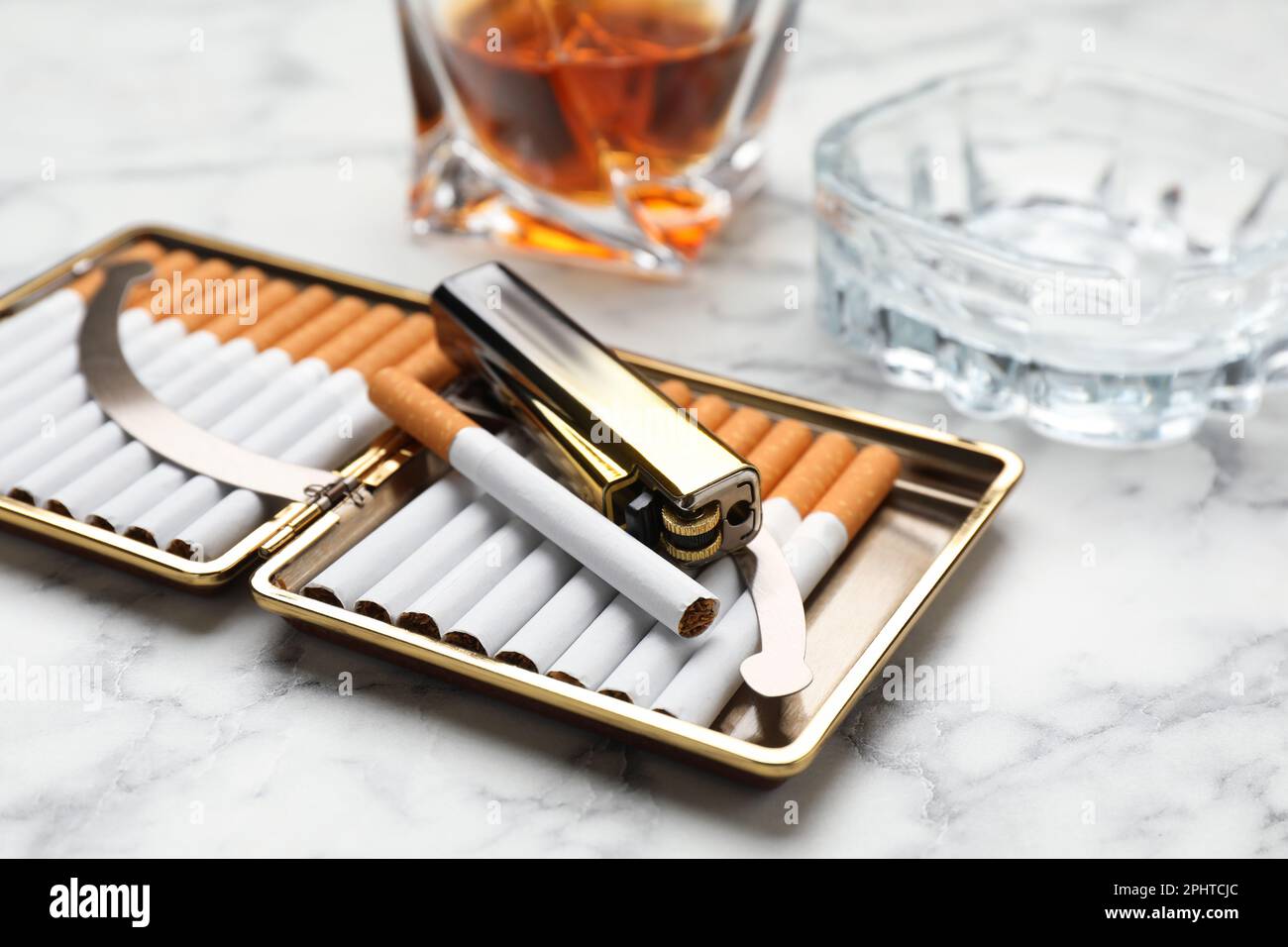 Open case with tobacco filter cigarettes, lighter, ashtray and alcohol ...