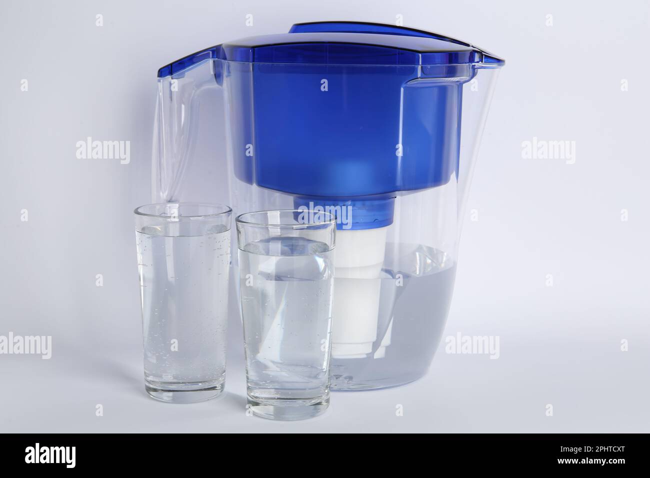 Filter jug and glasses with purified water on white background Stock ...