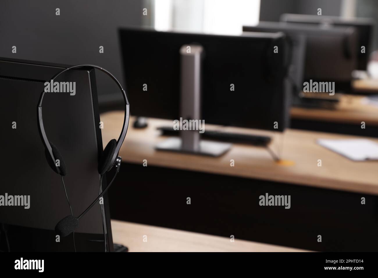 Modern computer with headset in office. Hotline service Stock Photo - Alamy