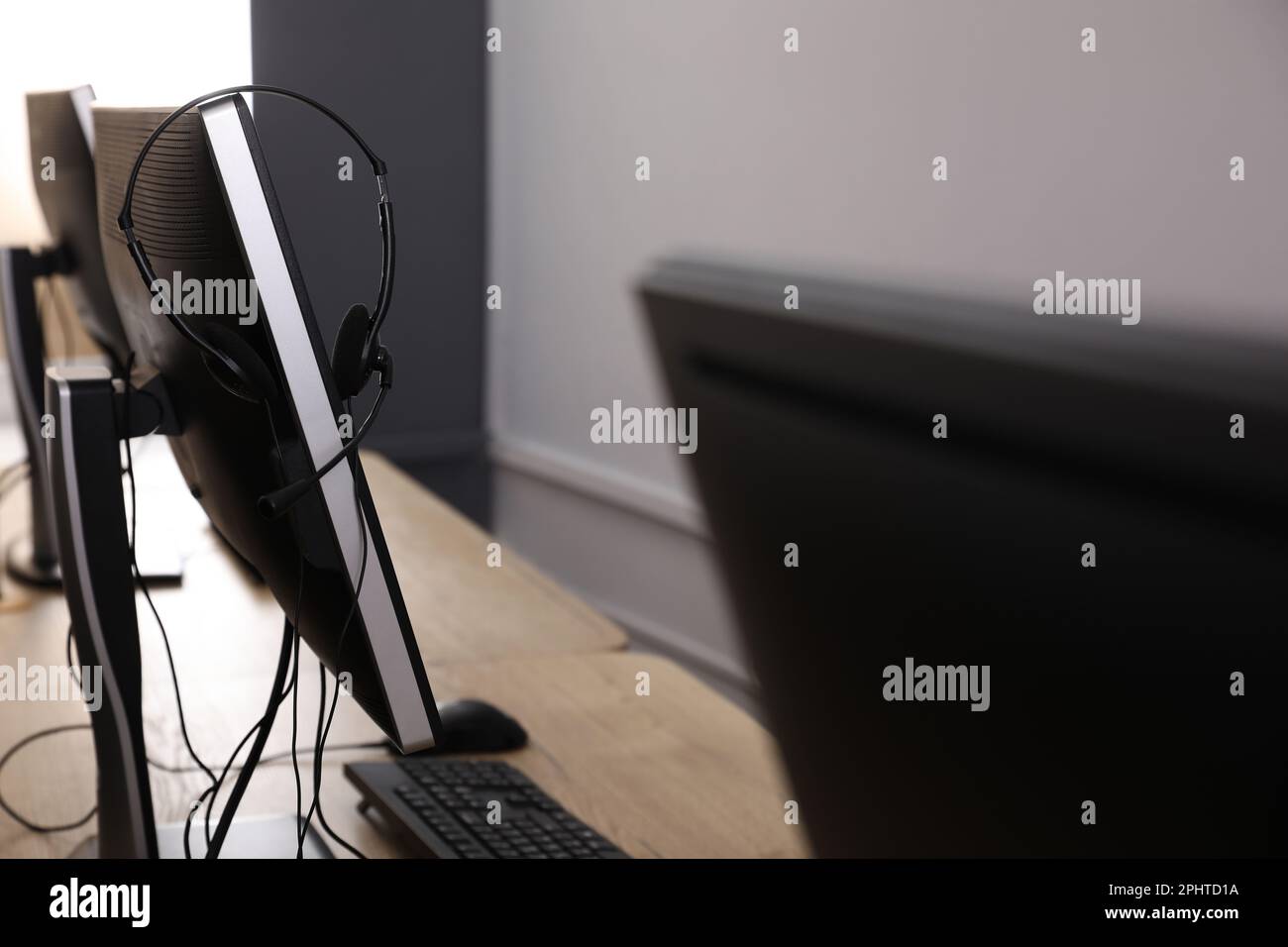 Modern computer with headset in office. Hotline service Stock Photo - Alamy