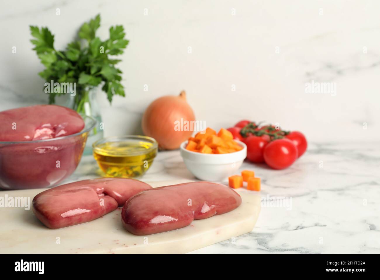 Fresh raw pork kidneys and ingredients on white marble table, space for ...