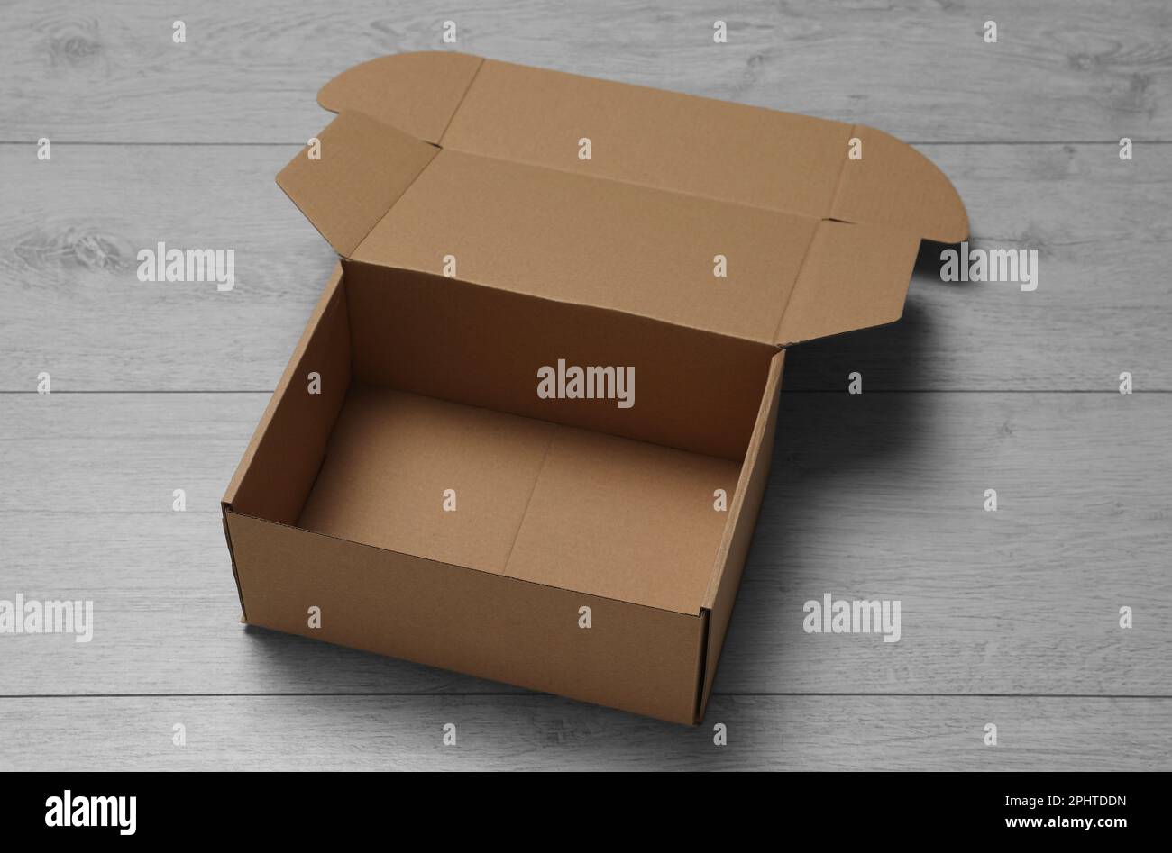 One empty open cardboard box on floor Stock Photo - Alamy