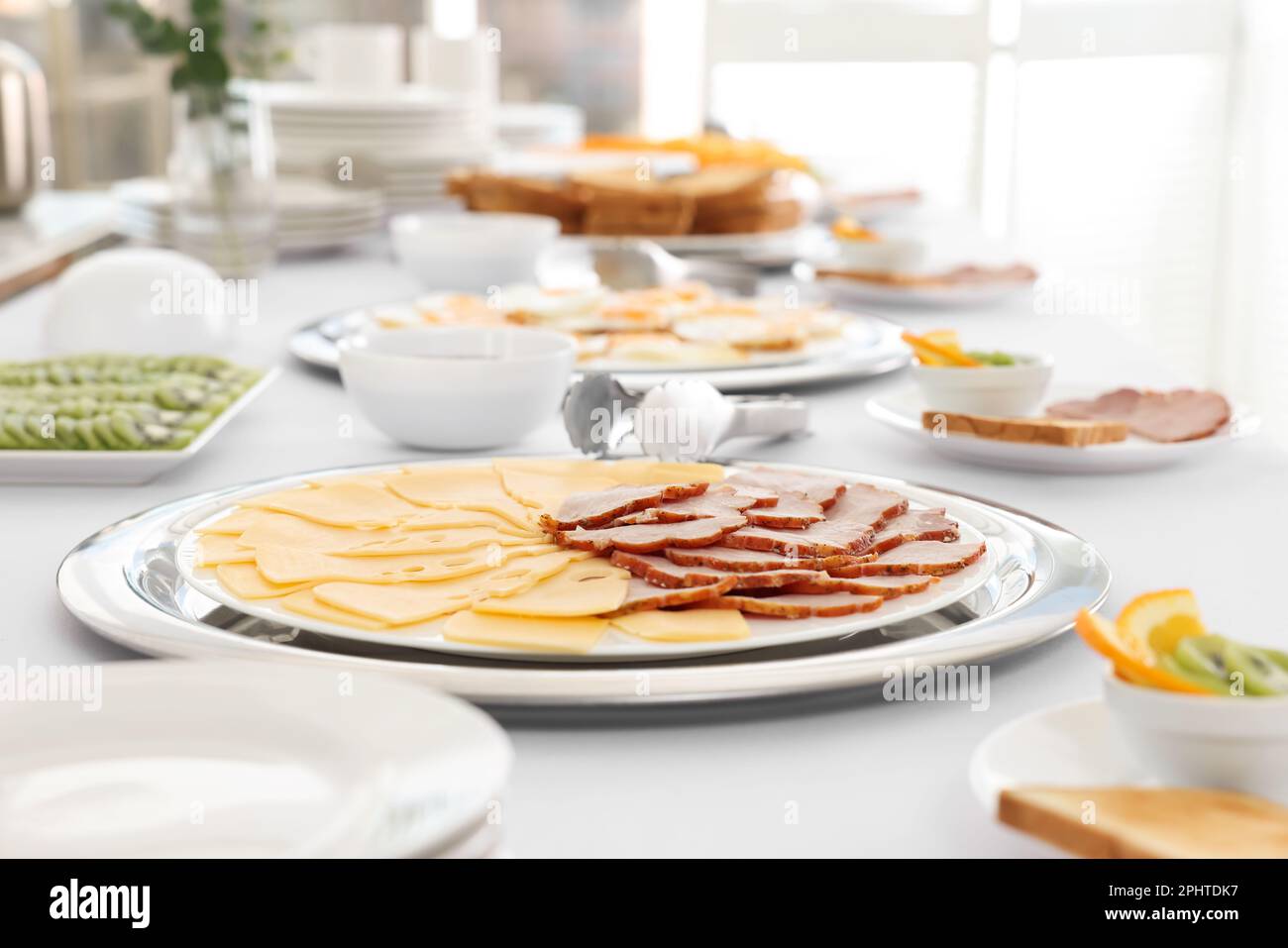 Different meals for breakfast on white table indoors. Buffet service ...