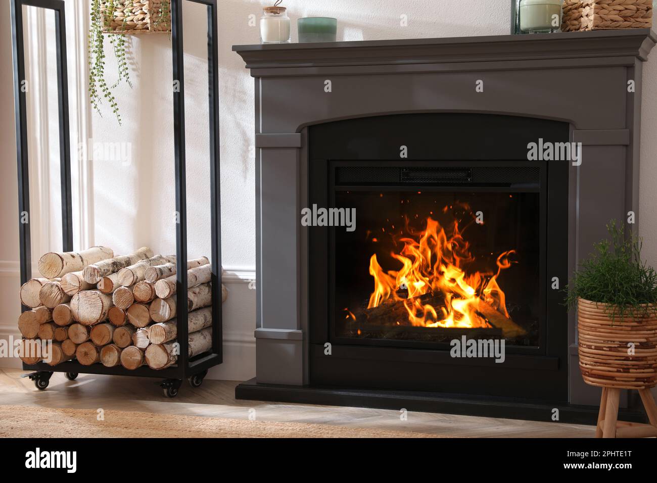 Electric fireplace, rack with wood and beautiful decor elements indoors ...