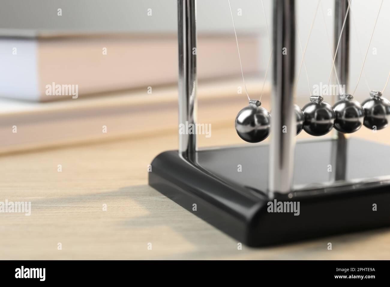 Newton's cradle on wooden table, closeup. Physics law of energy ...