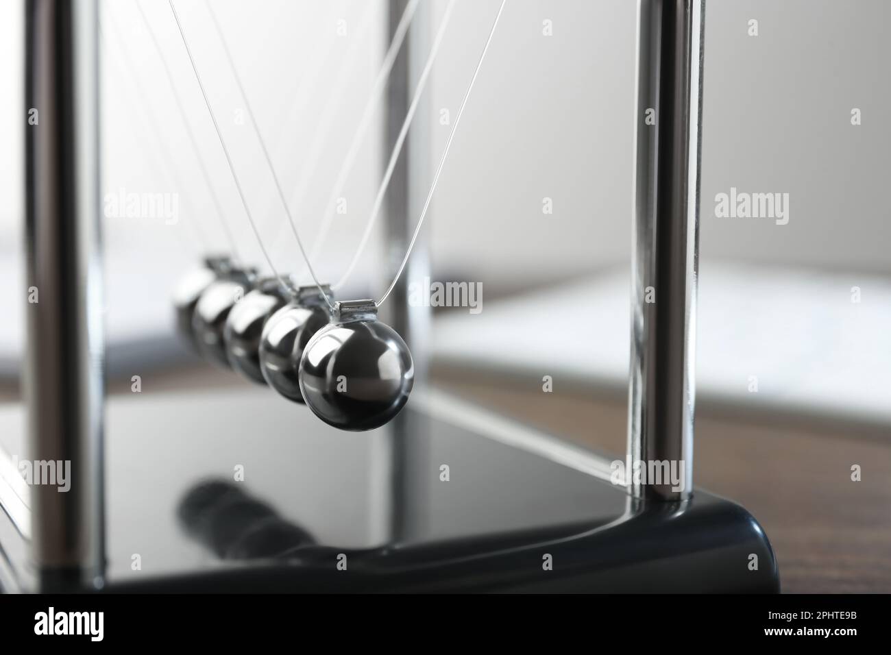 Newton's cradle on wooden table, closeup. Physics law of energy ...