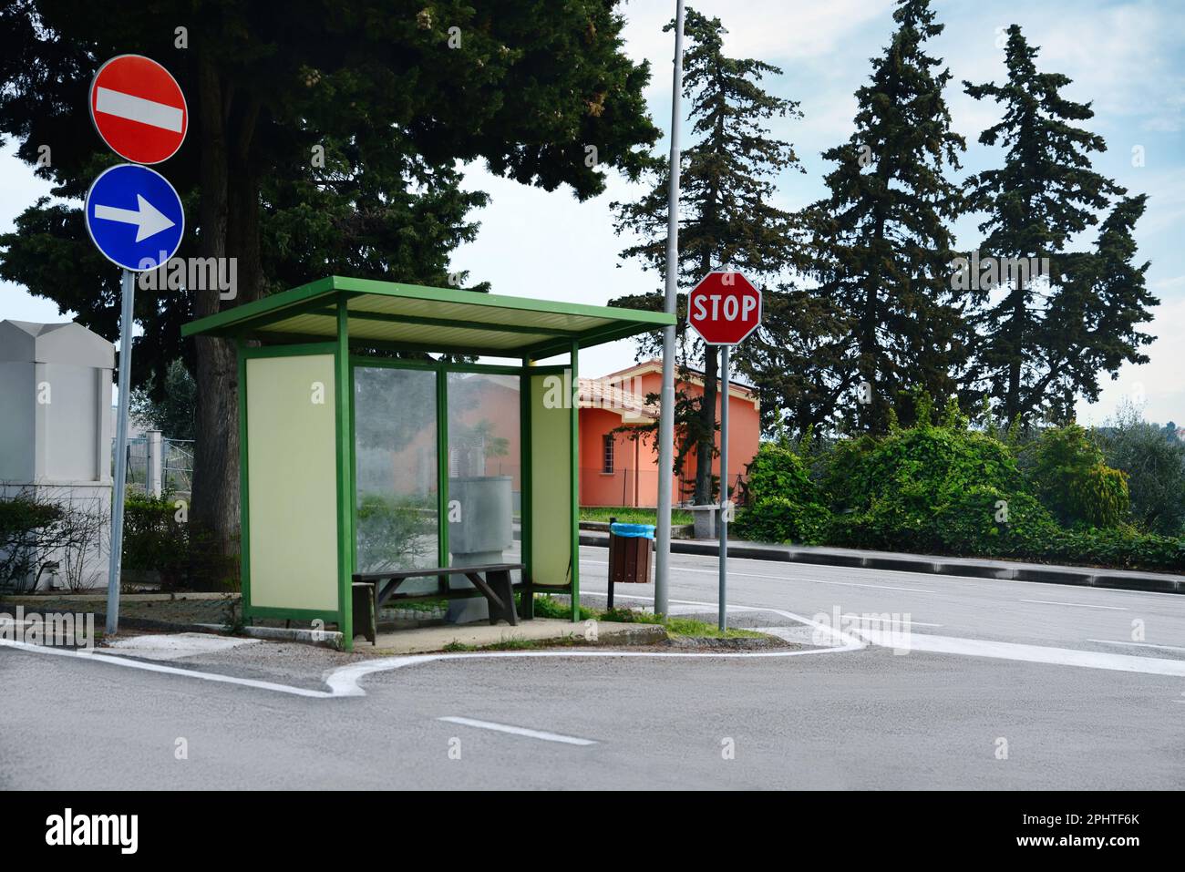 Posts with traffic signs near bus stop Stock Photo - Alamy