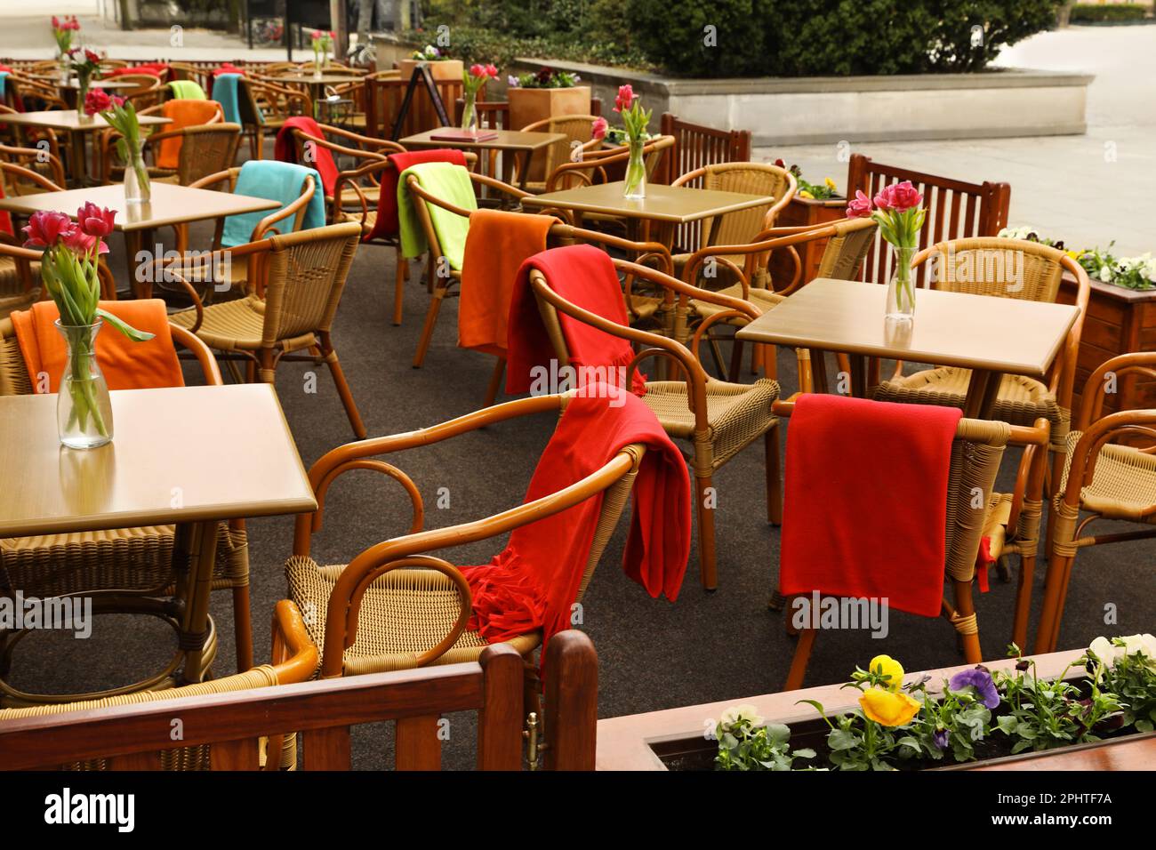 Outdoor cafe with wicker chairs and wooden tables Stock Photo - Alamy
