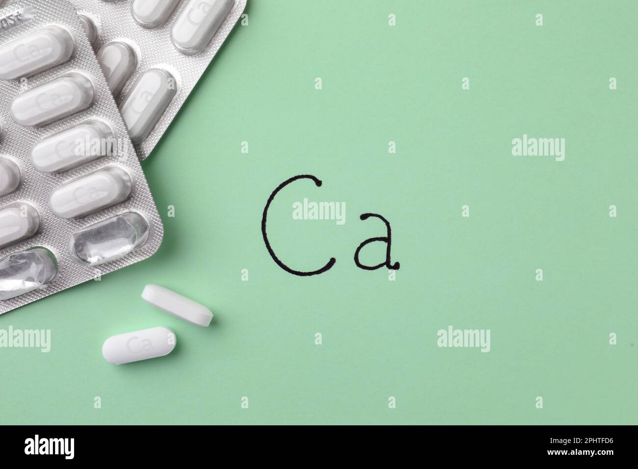 Blister packs with calcium supplement pills on light green background ...