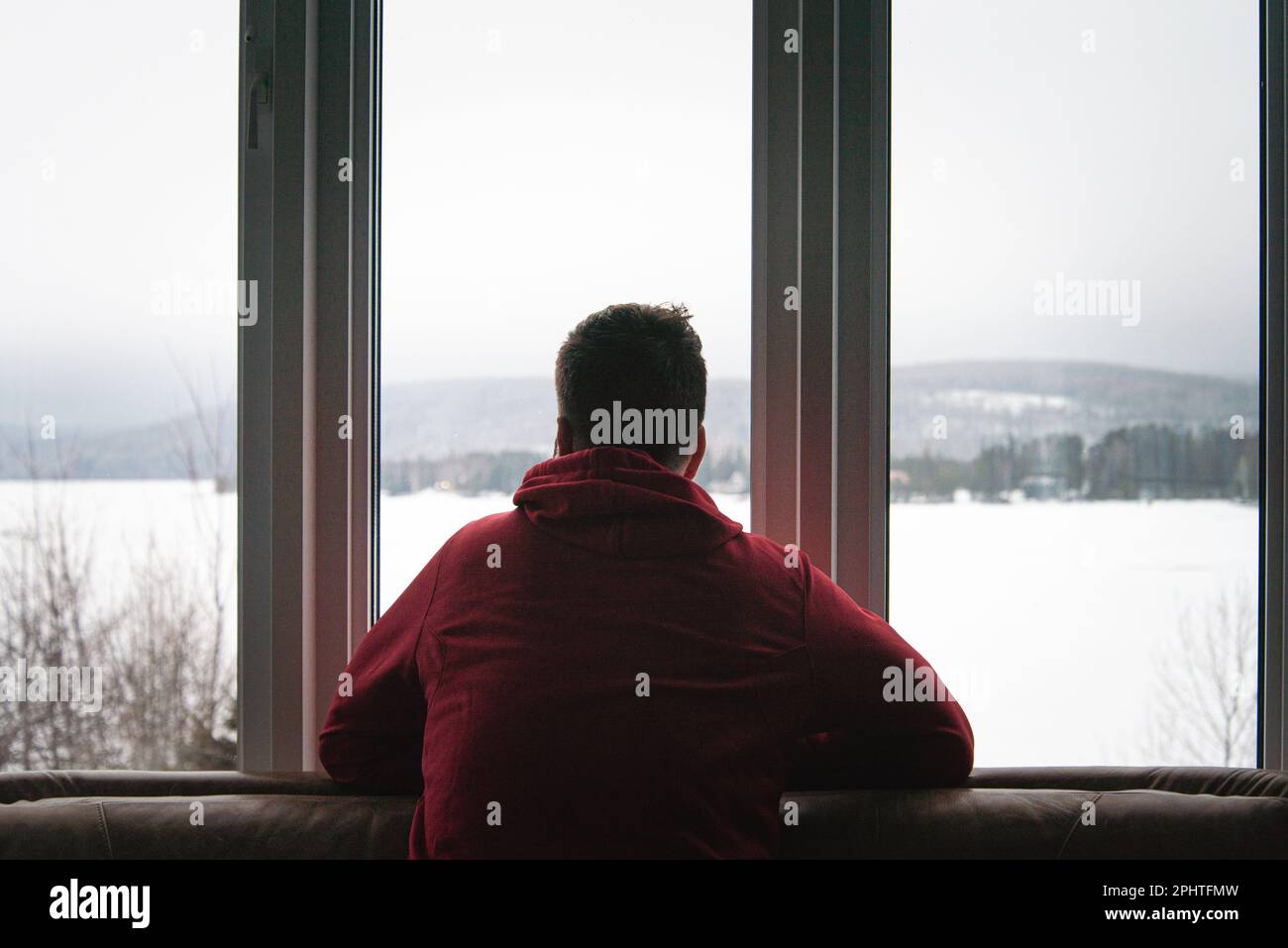 Sad man looking out the window during a foggy winter day Stock Photo ...
