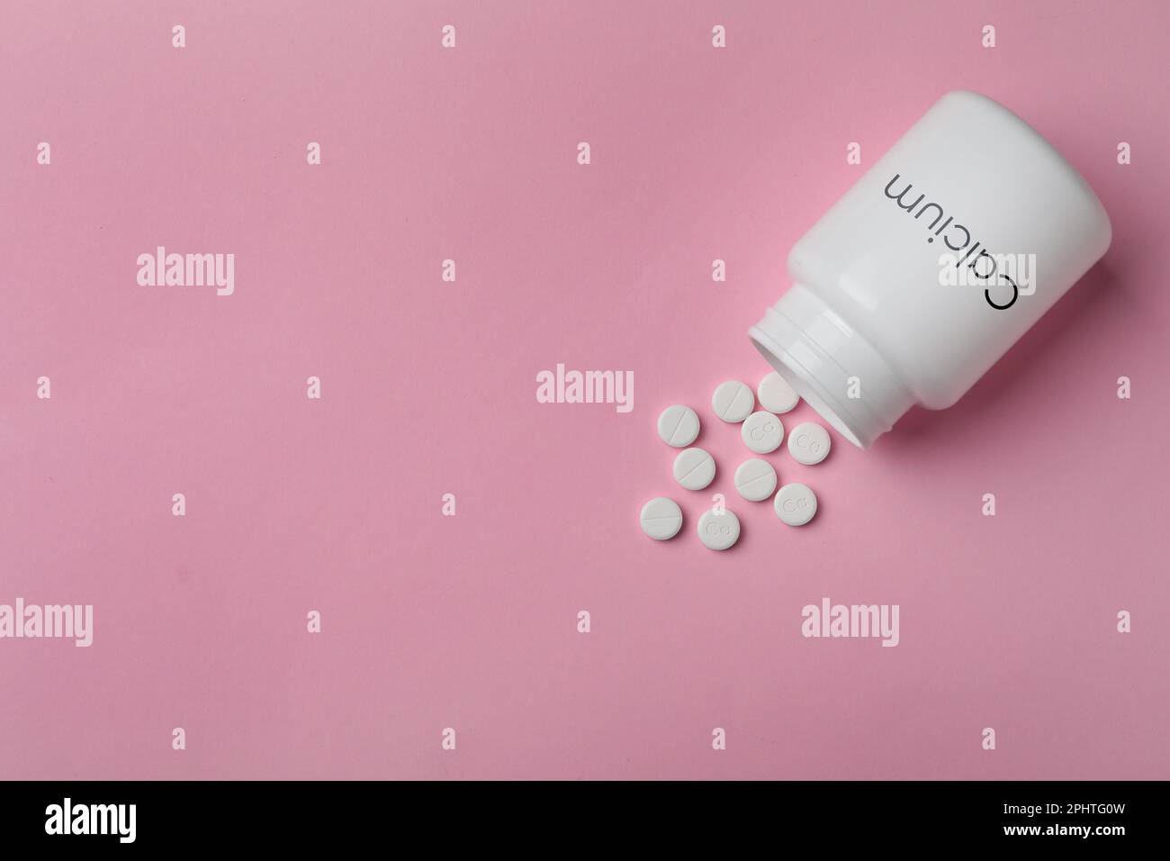 Calcium supplement. Bottles with pills on pink background, flat lay and ...