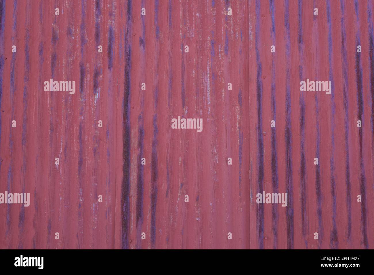 Rusted, red corrugated metal panel with black streaks. Textured wall ...