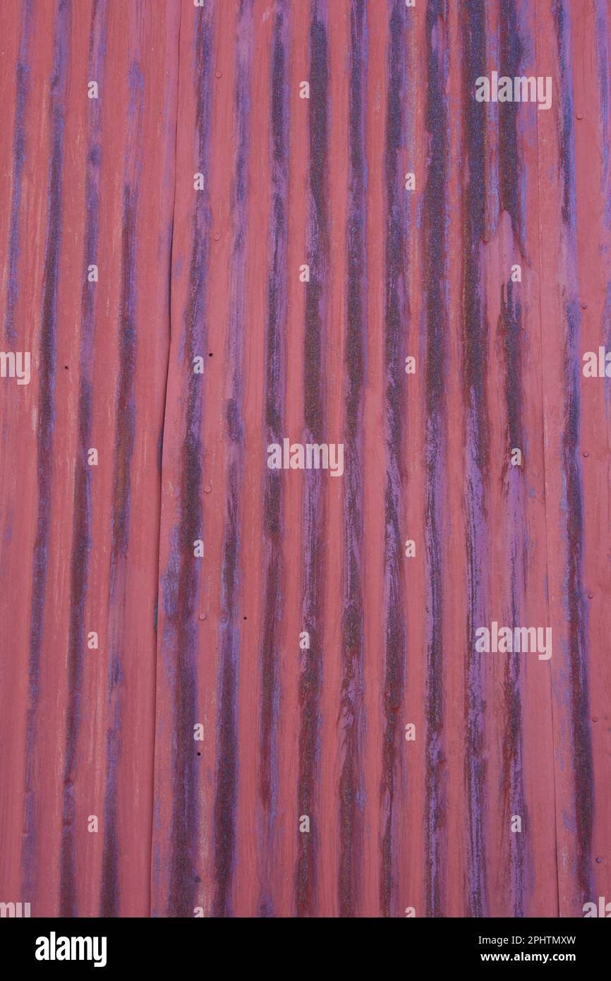 Rusty, red corrugated metal panel with black streaks. Textured wall ...