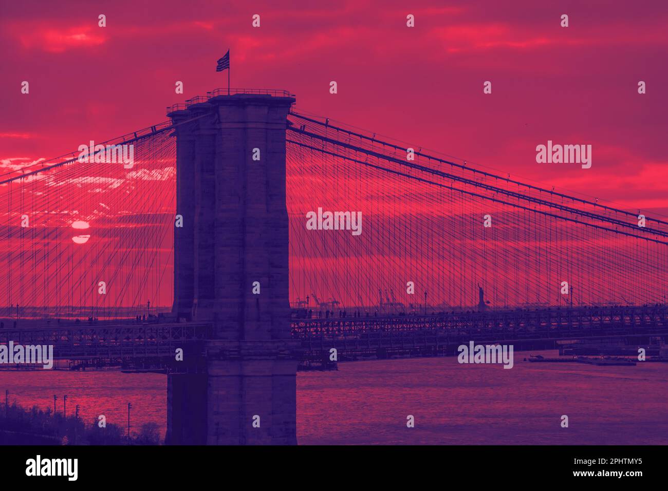 The setting sun paints a colorful sky behind the Brooklyn Bridge in New ...