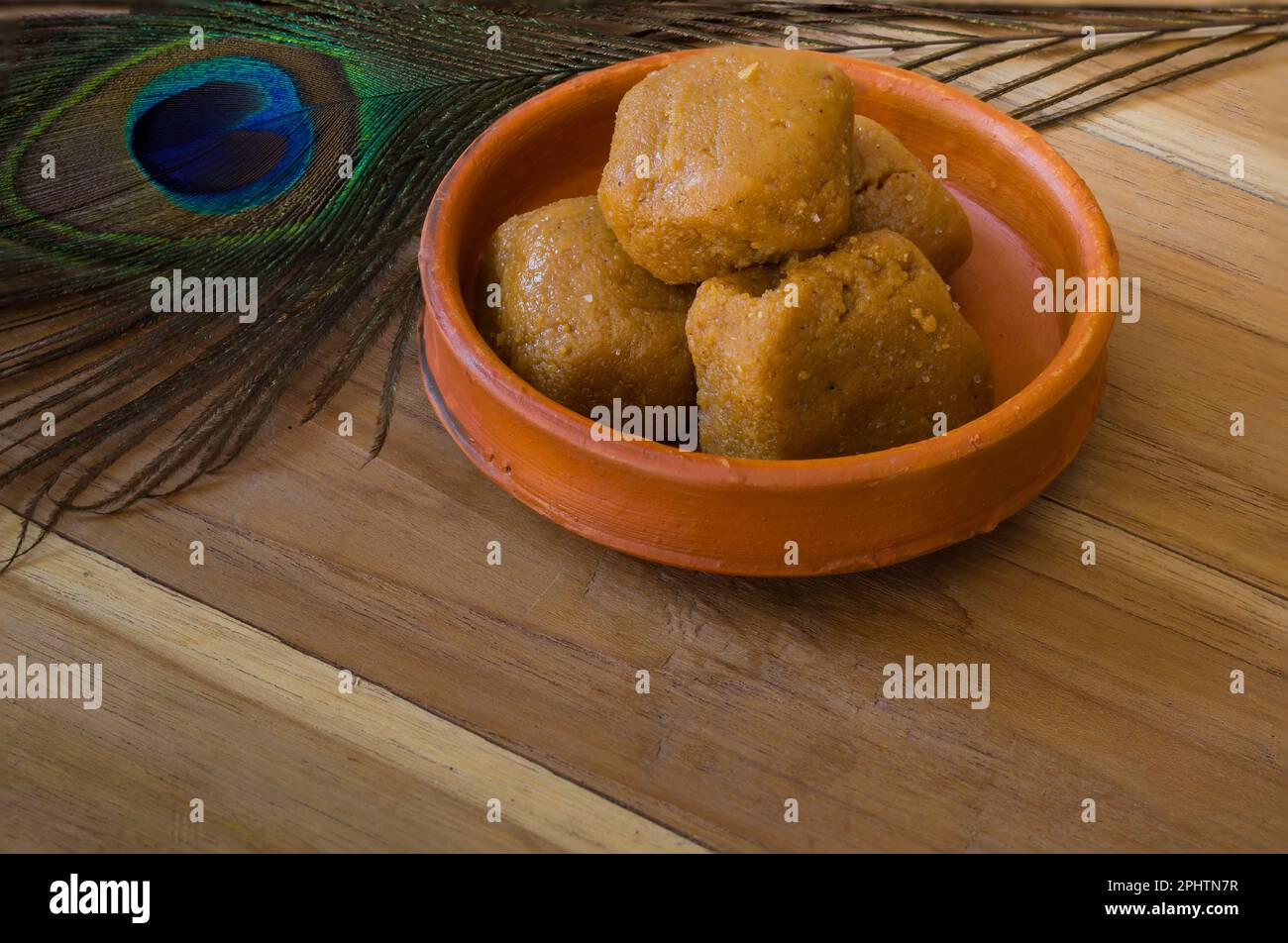 Mathura ka peda is served on a clay plate with peacock feather during ...
