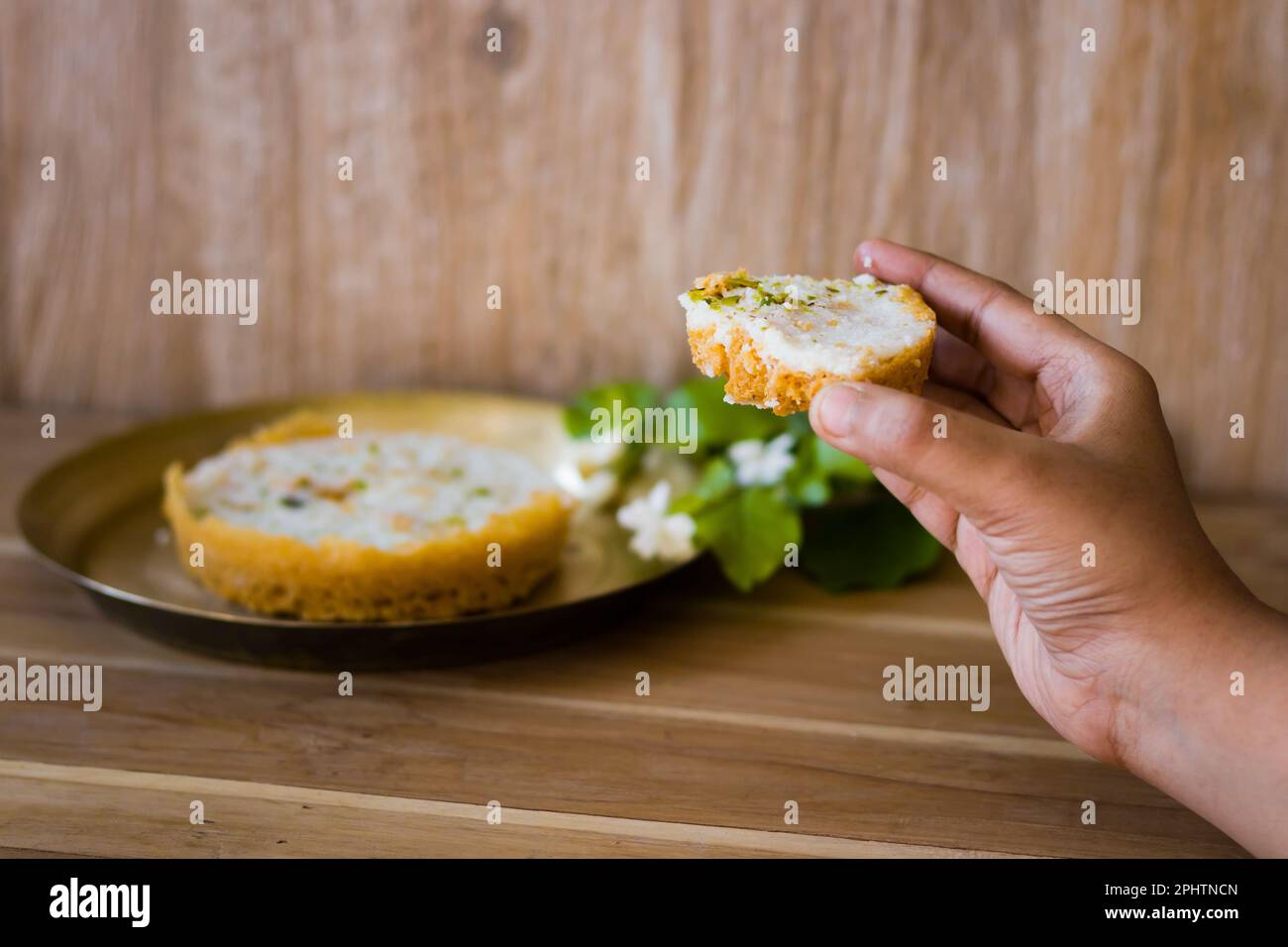 hand holding a piece of Ghewar or ghevar, which is a traditional sweet ...