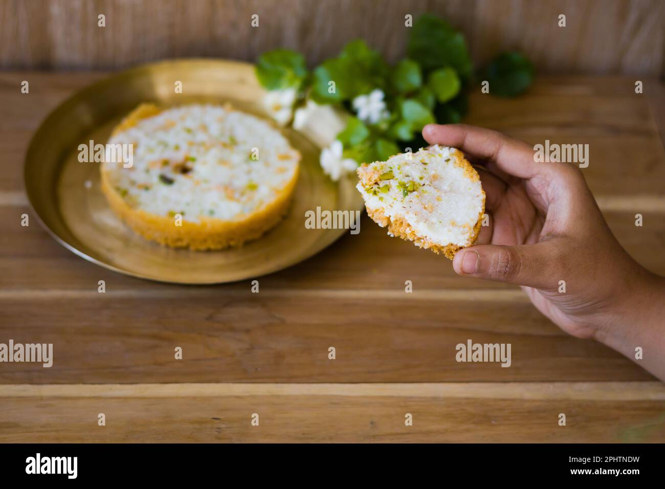 hand holding a piece of Ghewar or ghevar, which is a traditional sweet ...