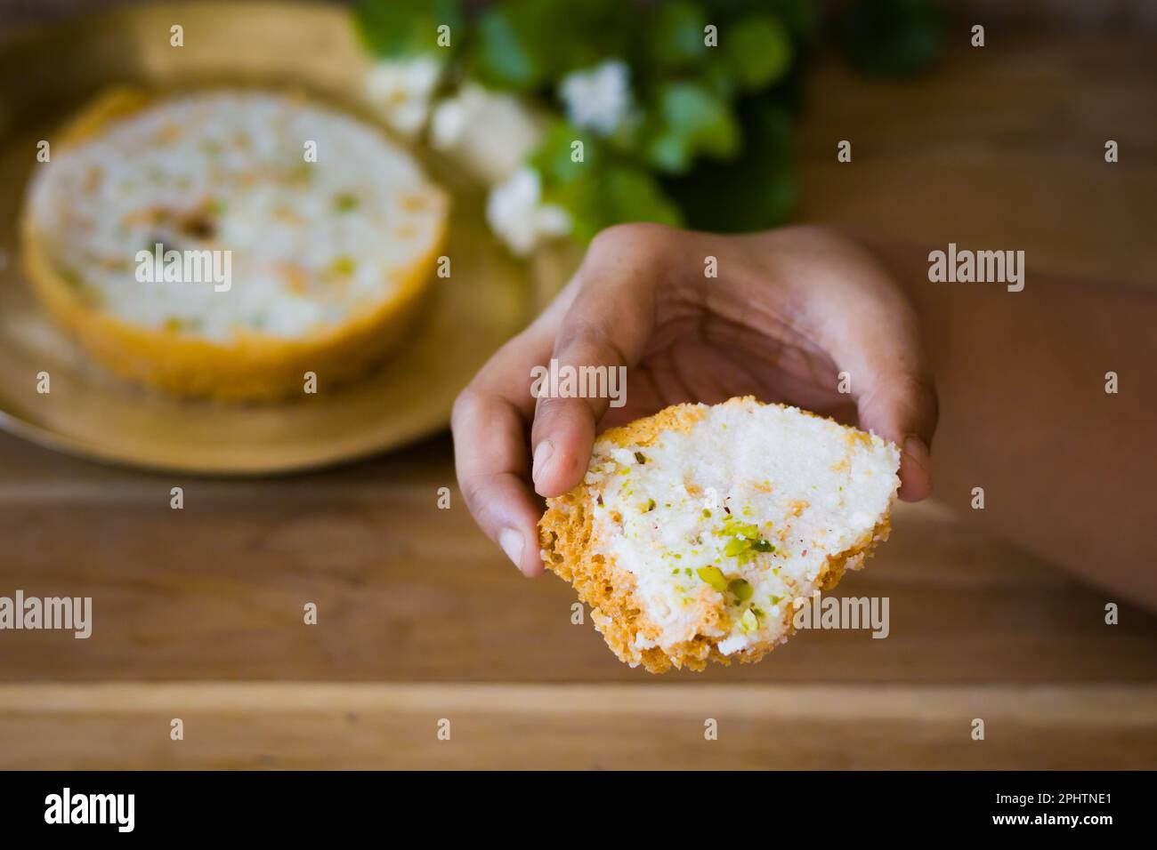 hand holding a piece of Ghewar or ghevar, which is a traditional sweet ...