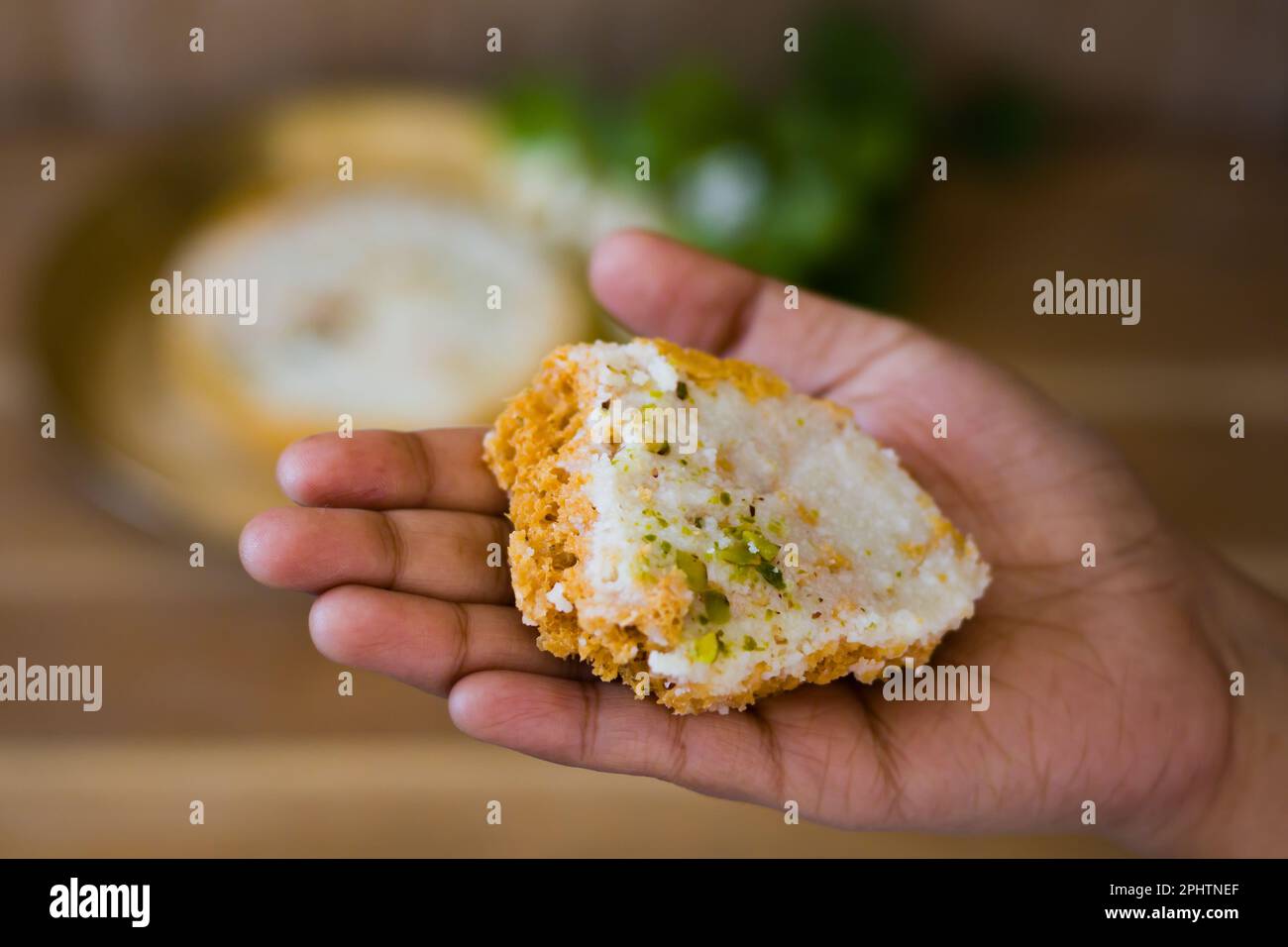 hand holding a piece of Ghewar or ghevar, which is a traditional sweet ...